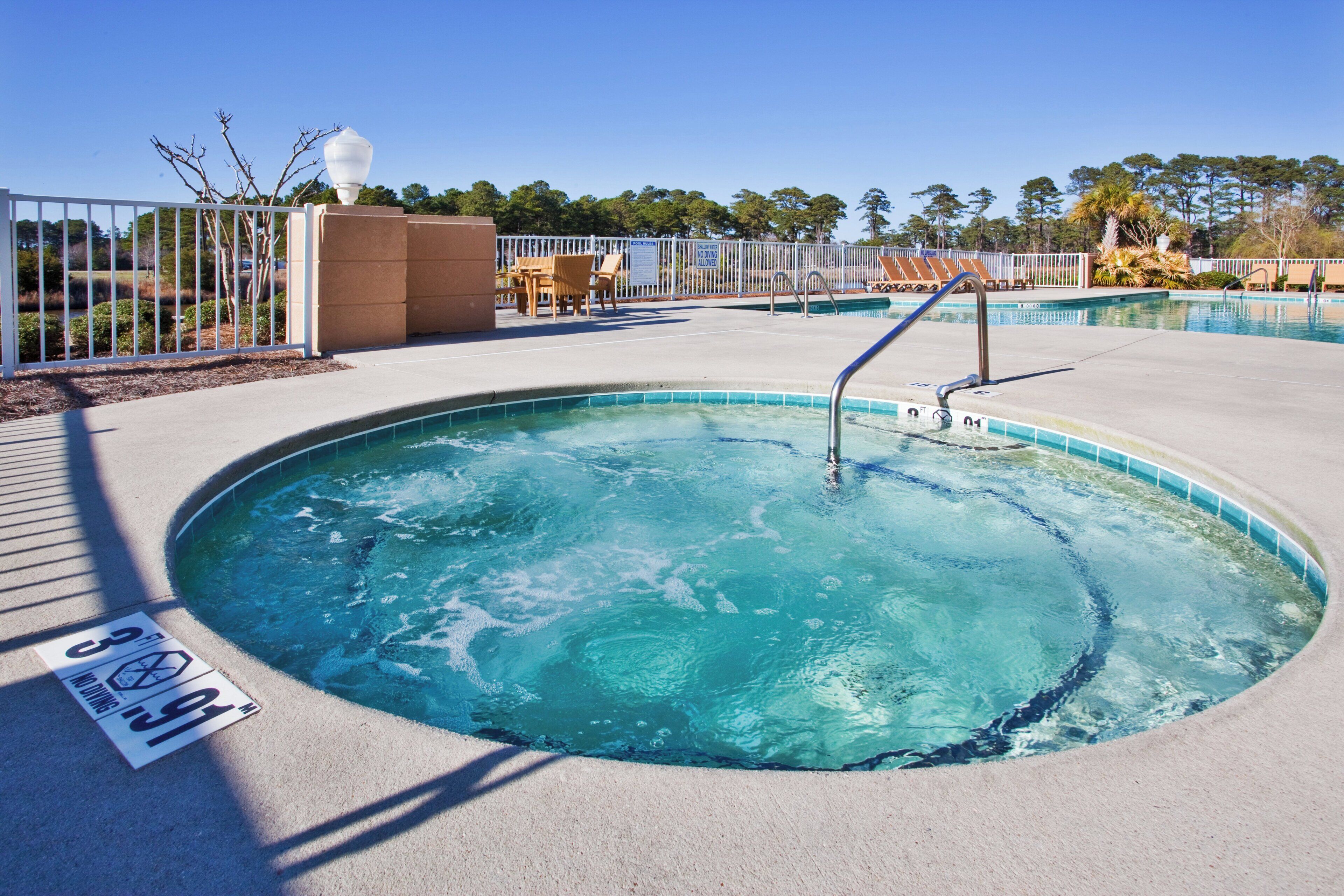 Uma banheira de hidromassagem com piscina, cercada por uma grade, e uma placa indicando que mergulhos não são permitidos.