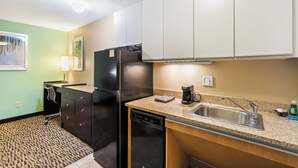 Cozinha compacta com lava-louças, geladeira, pia e cafeteira.