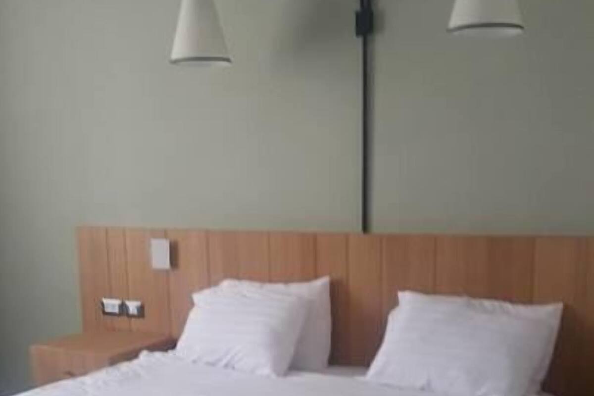 Cama bem arrumada com lençóis brancos em um quarto de hotel.