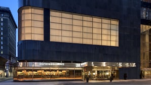 Um hotel moderno com fachada curva, janelas amplas e entrada imponente.