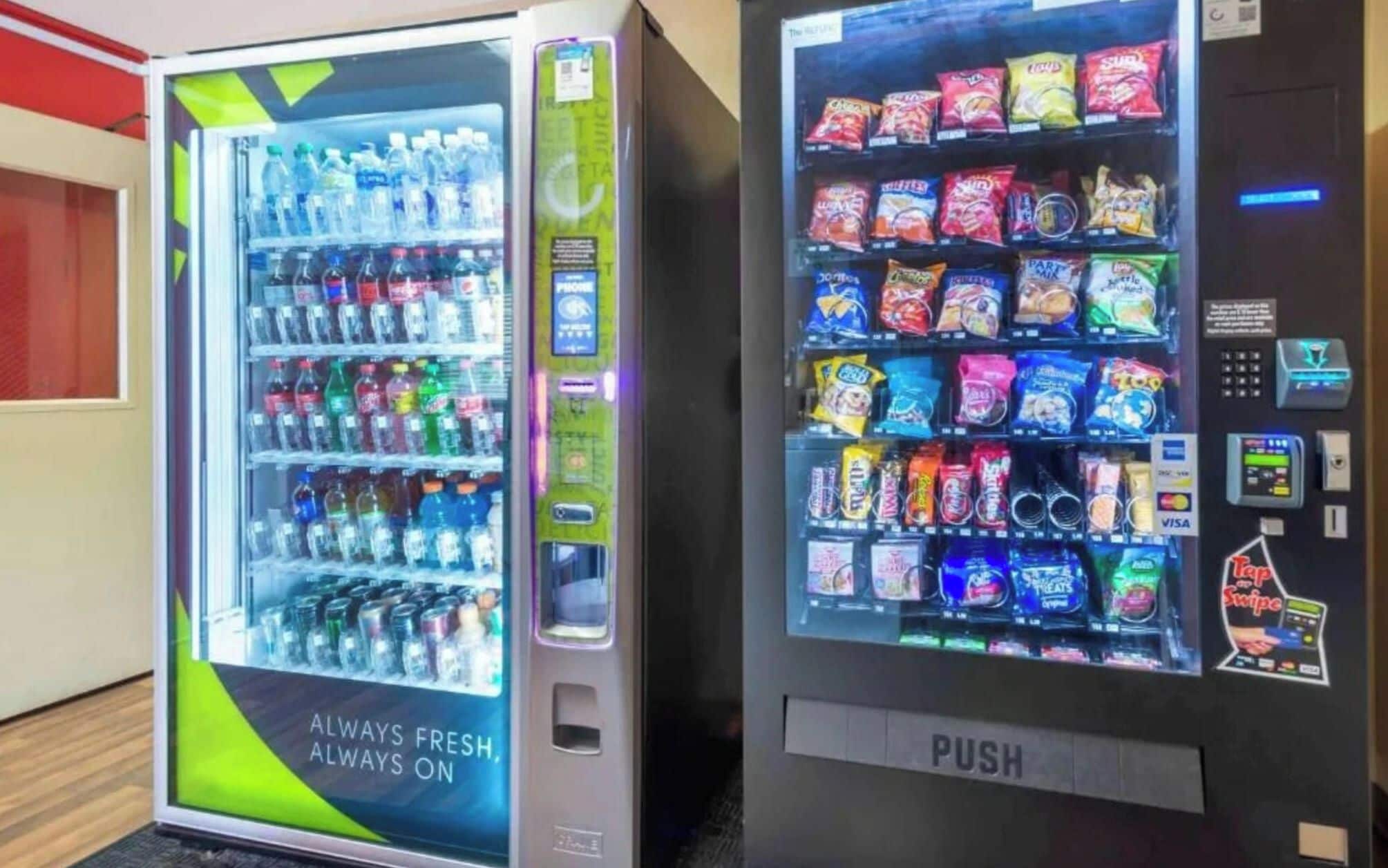 Duas máquinas de venda automática: uma com garrafas de água e outra com petiscos.