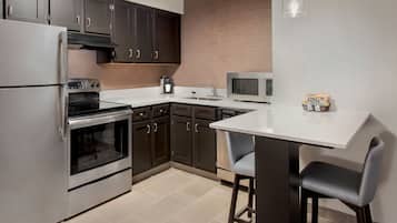 Um frigorífico/congelador grande, um micro-ondas, uma placa de cozinha