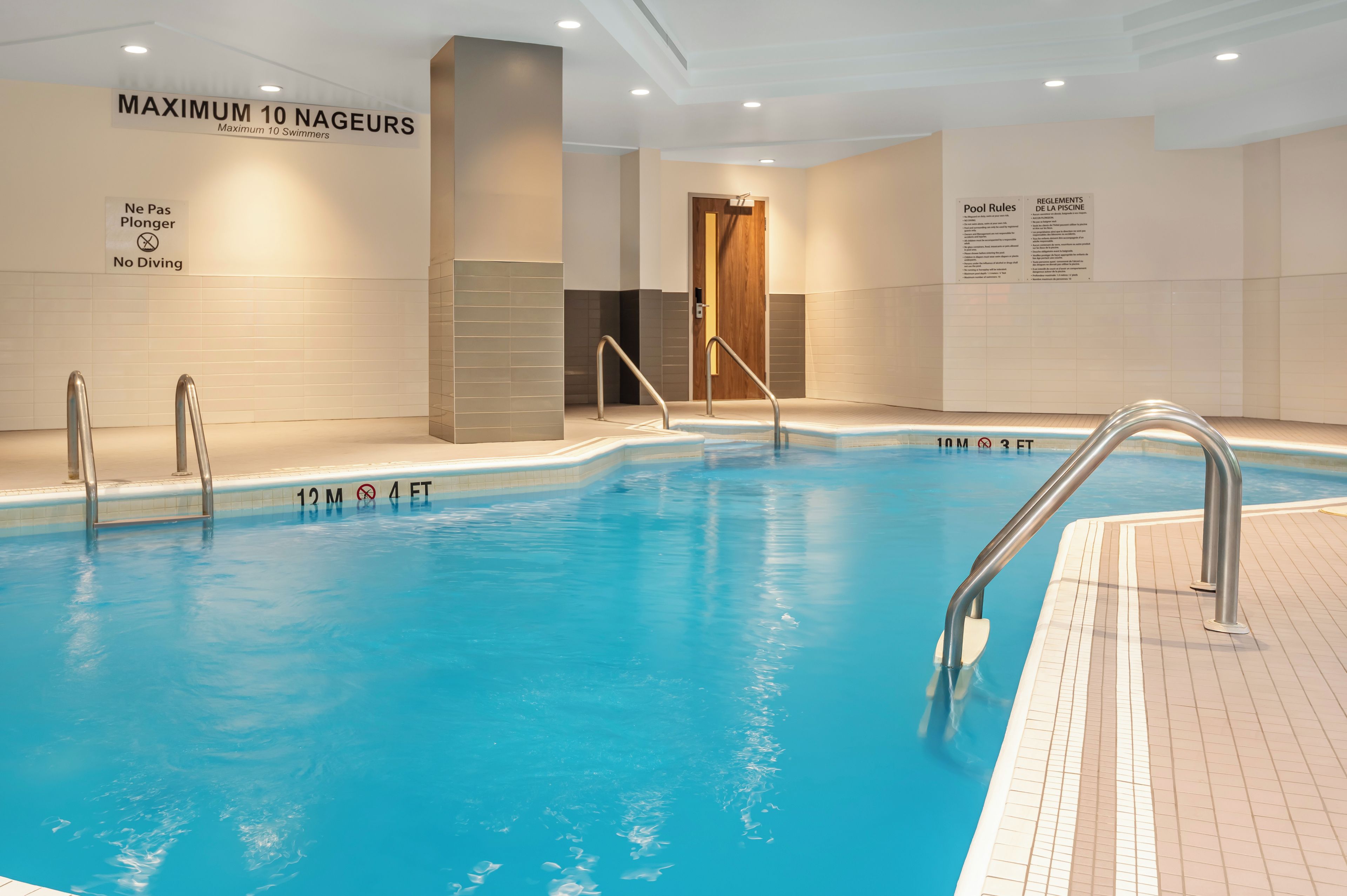 Piscina interna com placa indicando limite máximo de 10 banhistas.