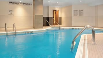 Piscina interna com placa indicando limite máximo de 10 banhistas.