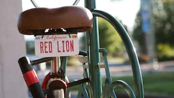 Bicicleta com placa de licença da Califórnia que diz 'RED LION' estacionada perto de um edifício.