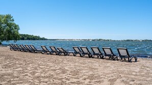 Uma praia com fileiras de espreguiçadeiras voltadas para o mar.