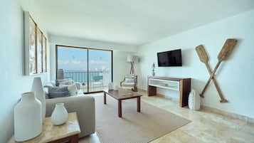 Spa Oceanfront Suite with Jacuzzi | Área de estar | Smart TV 42 polegadas com canais digitais, TV, livros