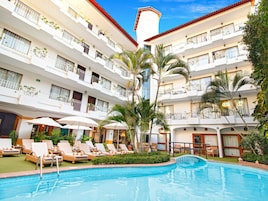 Um hotel com piscina, várias varandas e espreguiçadeiras.