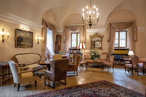 Uma sala de estar ampla com teto alto, móveis elegantes e um candelabro.