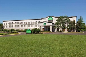 Um hotel Wingate com um prédio grande, várias janelas e uma placa verde.