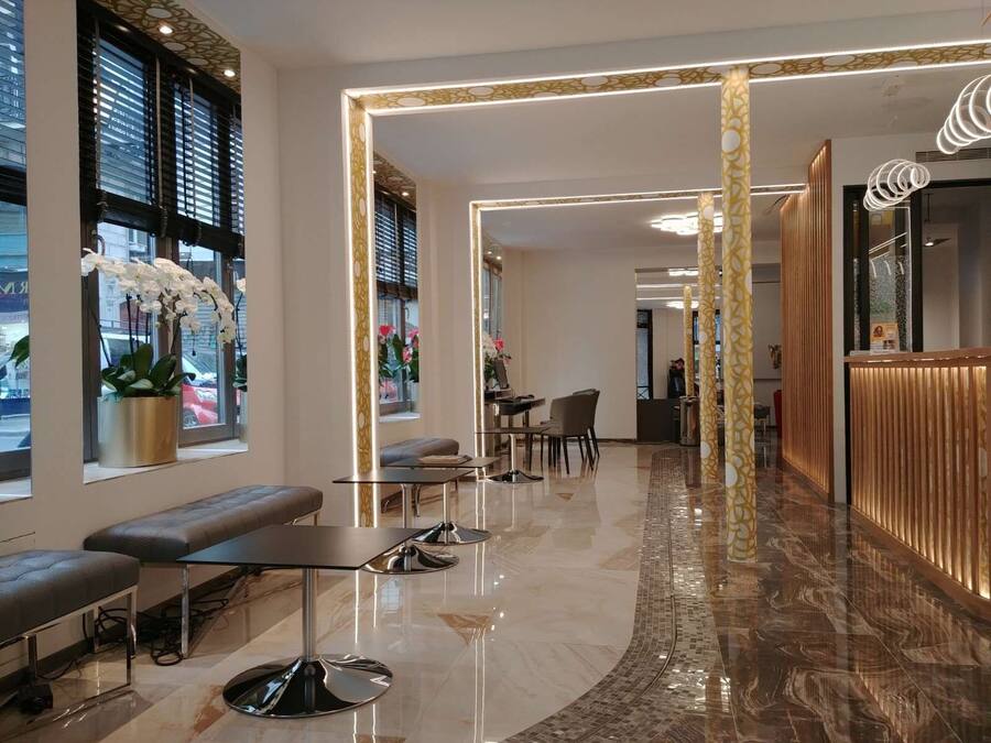 Um lobby moderno com assentos, balcão de recepção e piso estampado.