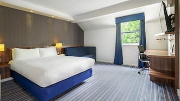 Quarto de hotel com uma cama grande, uma mesa e uma cadeira.