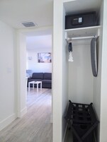 Uma sala de estar moderna com um sofá cinzento, uma mesa de centro branca e um quadro com uma cena de praia.