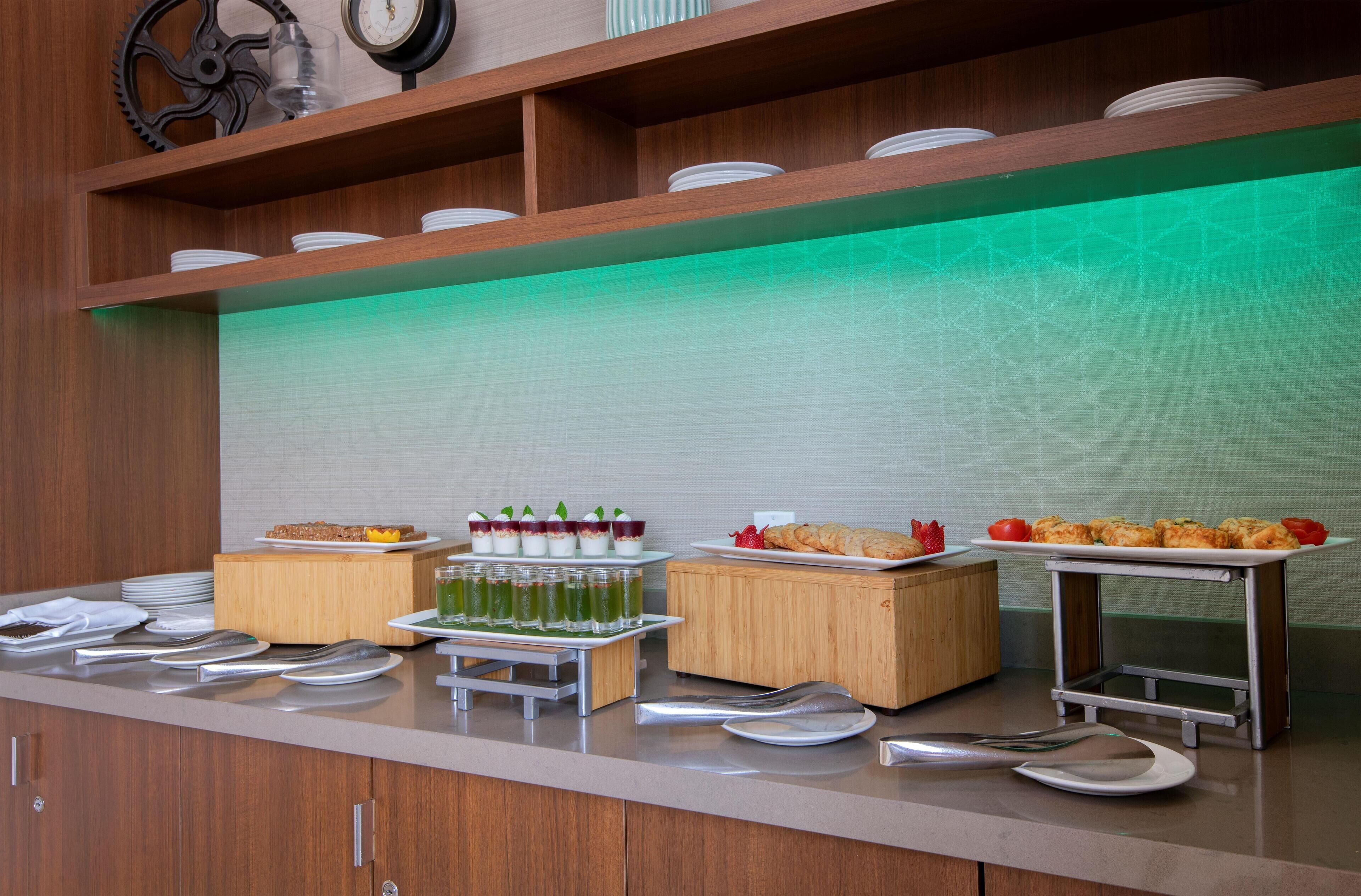 Uma mesa de buffet com diversos alimentos e utensílios.