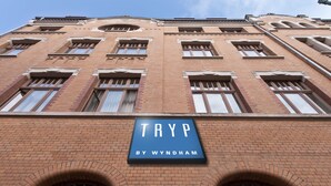 Um edifício de tijolos com uma placa que diz 'TRYP BY WYNDHAM'.