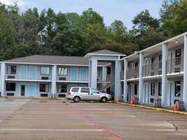 Um motel com vários andares, estacionamento e escadas que levam aos níveis superiores.