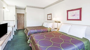 Quarto de hotel com duas camas, uma televisão, uma escrivaninha e uma porta que dá para outro quarto.