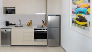 Uma cozinha moderna com eletrodomésticos de aço inoxidável, máquina de lavar louça e pia.