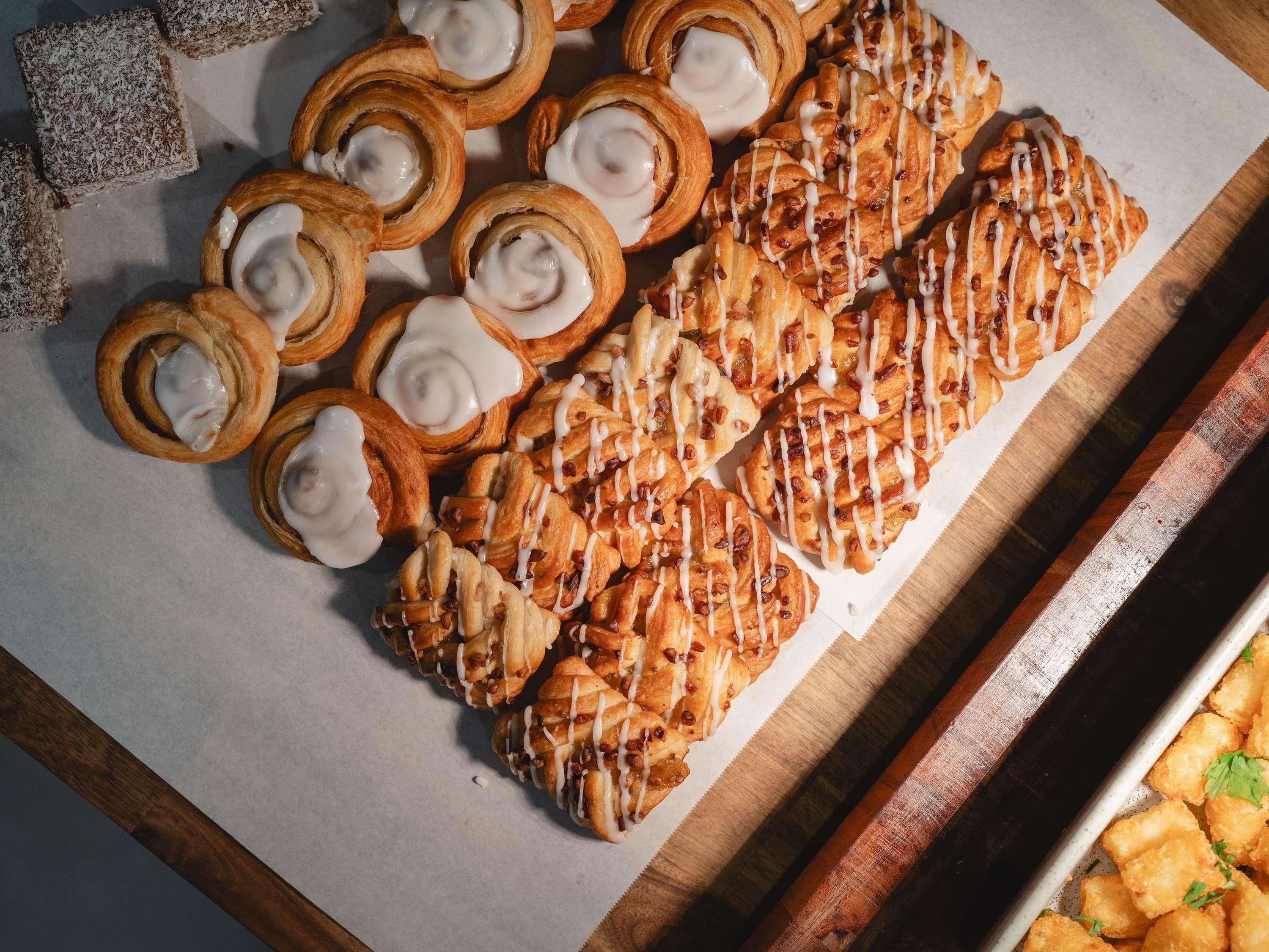 Diversos doces e pastéis sobre uma tábua de madeira.