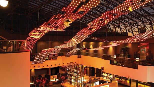 Amplo espaço interno com diversas áreas de estar e um bar.