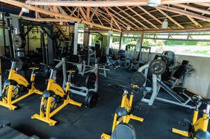 Uma academia com diversos equipamentos de exercício, incluindo aparelhos de musculação e equipamentos cardiovasculares.