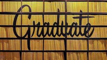 Paredes de madeira com um padrão de grade e a palavra 'Graduate' escrita sobre elas.