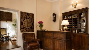 A traditional room with a wooden desk, a leather chair, a patterned rug, and a wall clock.