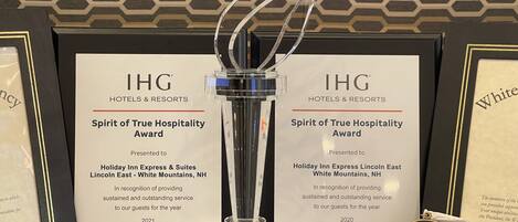 Duas placas premiadas Spirit of True Hospitality Awards da IHG Hotels & Resorts para Holiday Inn Express & Suites Lincoln East - White Mountains, NH, uma de 2021 e outra de 2020.