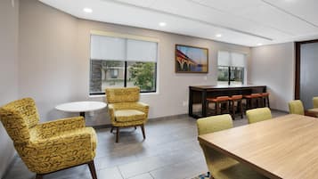 Uma sala de conferências com uma mesa grande, várias cadeiras e um quadro na parede.