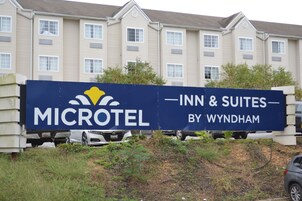 Placa da Microtel Inn & Suites com um edifício ao fundo.