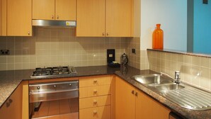 Uma cafeteira/bule, um frigorífico/congelador grande, um micro-ondas 