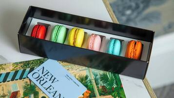 Caixa de macarons coloridos sobre uma mesa com um cartão que diz 'New Orleans'.