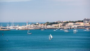 Uma marina com barcos e um farol ao fundo.