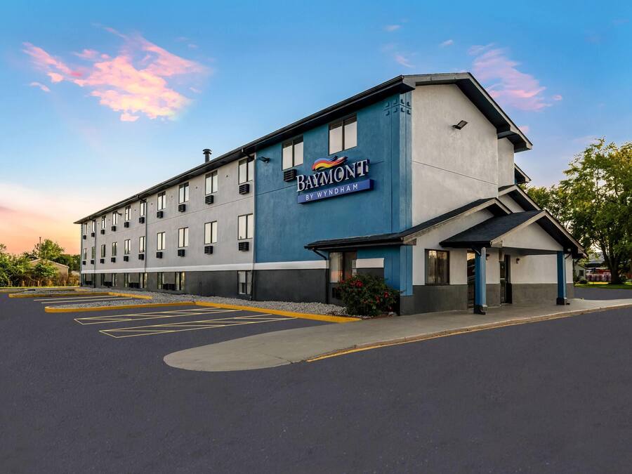 Um edifício moderno com uma placa indicando 'BAYMONT BY WYNDHAM', identificando um hotel.