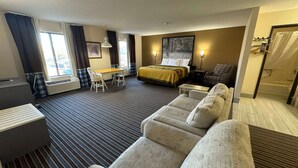 Quarto de hotel com cama, sofá, escrivaninha e cadeira.