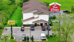 Um Super Inn e restaurante Bob Evans, com estacionamento e vegetação ao redor.
