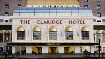 Fachada do Hotel Claridge com janelas em arco, toldo amarelo e bandeiras.