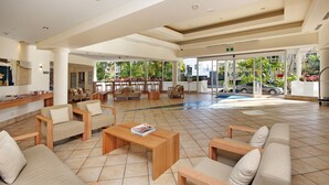 Um hall amplo com balcão de recepção, área de estar e vista para o exterior.