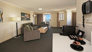 Quarto de hotel com área de estar, espaço para café e vista para a cidade.