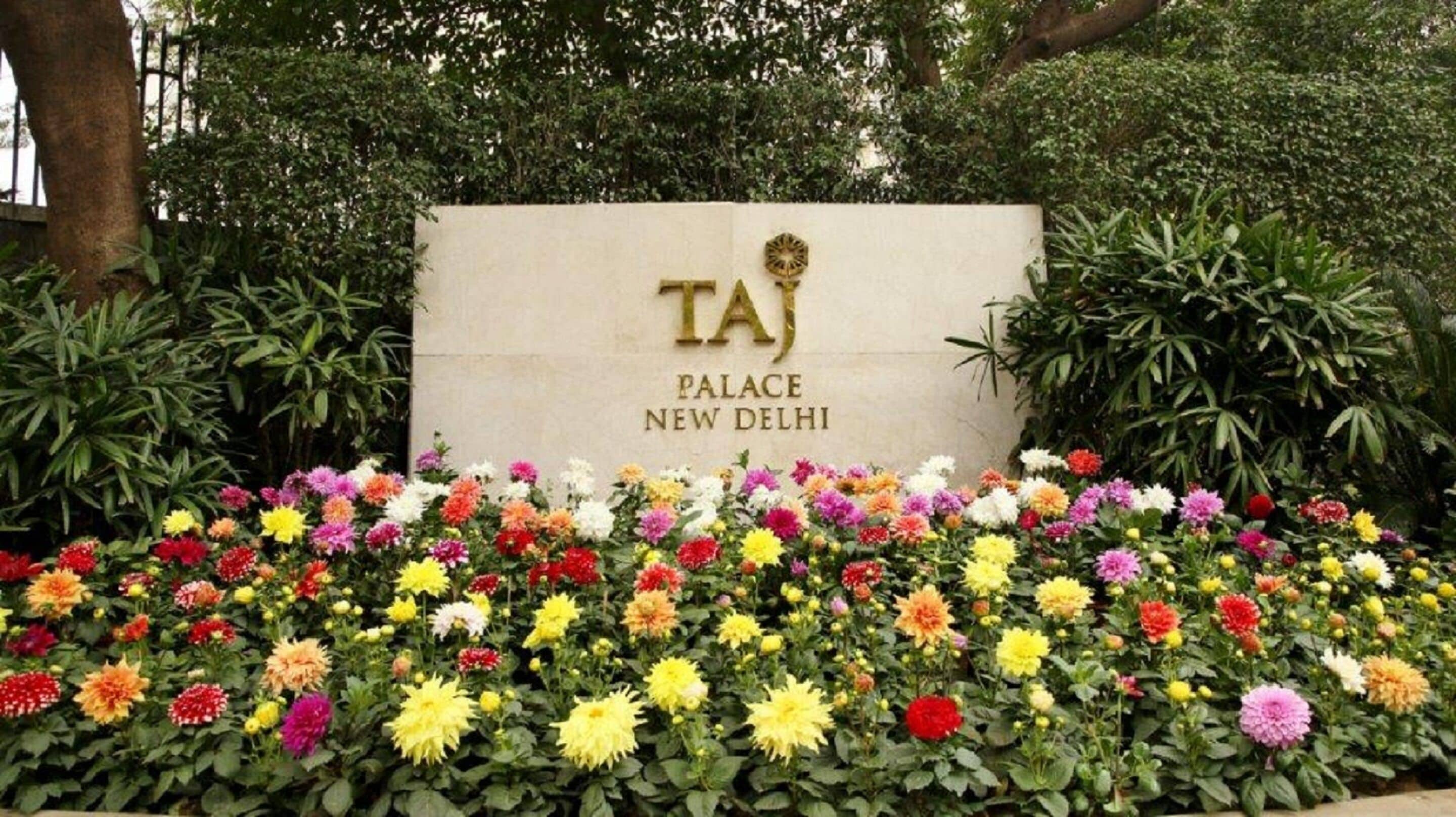 Placa do Taj Palace, Nova Delhi, com um arranjo floral à frente.