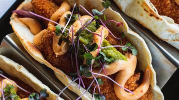 Uma bandeja com pratos de comida, provavelmente tacos, com diversos acompanhamentos e guarnições.