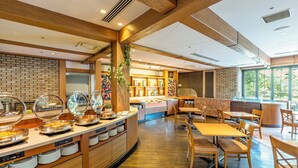 Uma área de buffet com várias estações de serviço, móveis de madeira e uma parede de tijolos.