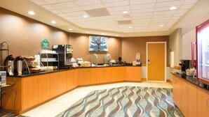 Cozinha de hotel com buffet, máquina de café e frigorífico.