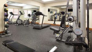 Academia com esteiras, elípticos e equipamentos de musculação.