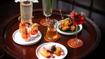 Uma bandeja com bebidas e pequenas porções de comida.