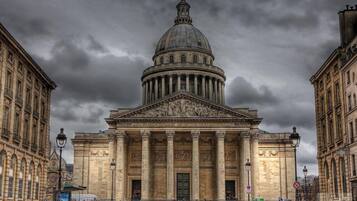 Um imponente edifício neoclássico com uma grande cúpula e colunas, cercado por outros edifícios históricos.