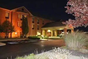 Hotel com fachada curva, várias janelas e entrada bem iluminada.