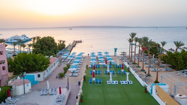 Um resort com piscina, espreguiçadeiras e guarda-sóis.