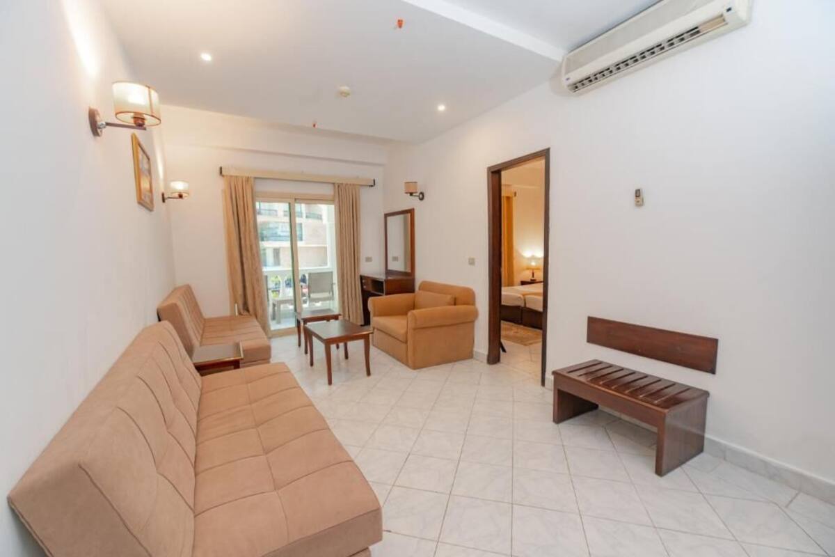 Uma sala de estar moderna com um sofá, um banco de madeira e uma pequena mesa.