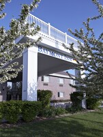 Edifício do Baymont Inn com fachada branca, janelas grandes e varanda com grades.